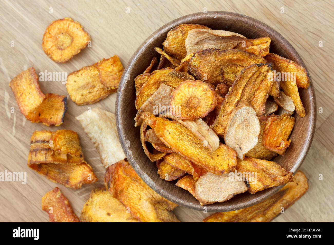 Fried carrot and parsnip chips in rustic wood bowl. From above Stock ...