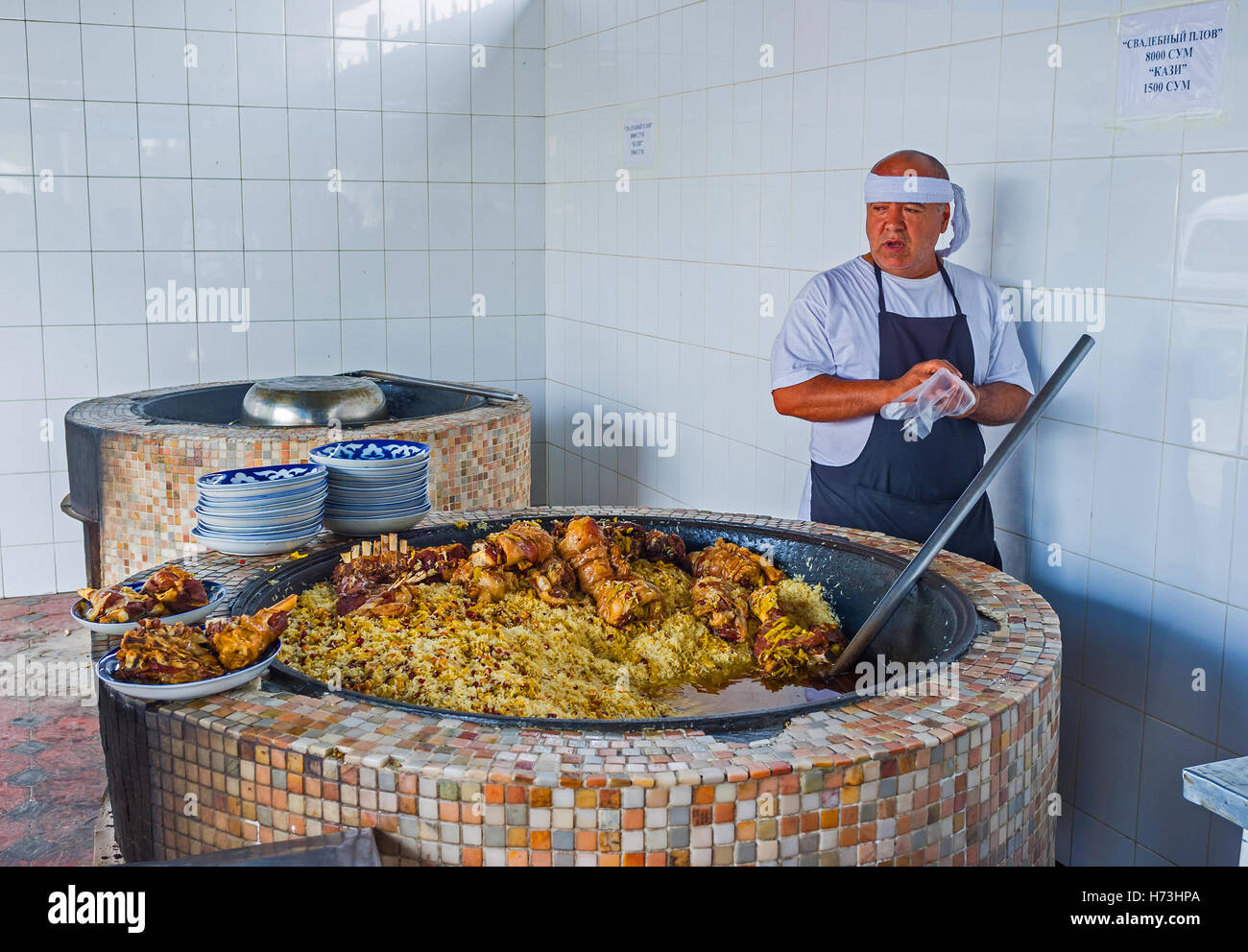 The chef next to the pilaf cauldron (qozon) in open air kitchen of ...