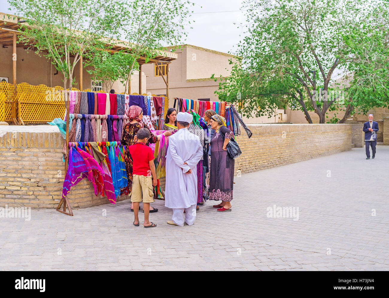 The members of Uzbek family in traditional costumes choose the ...