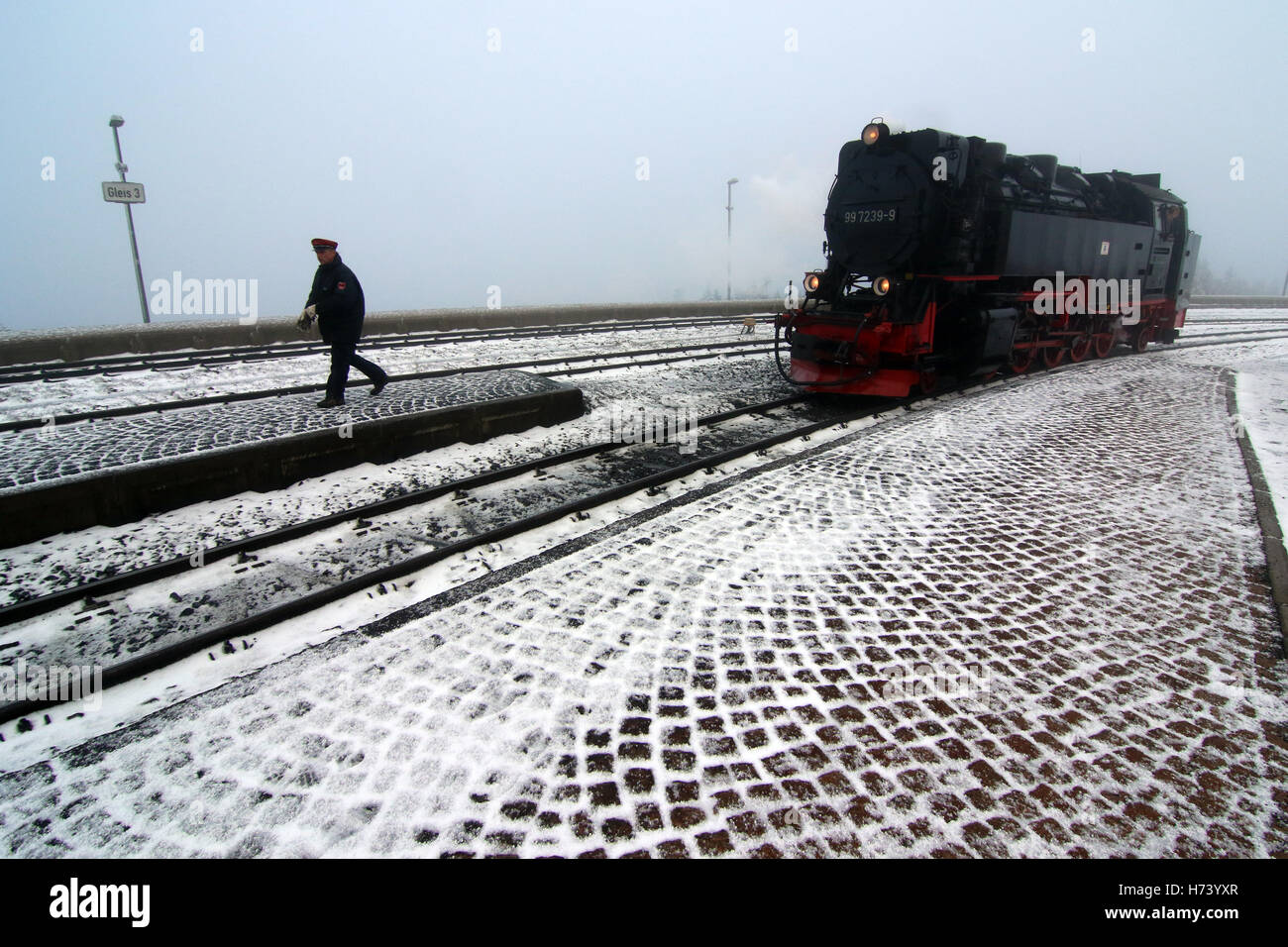 A steam locomotive of the HSB drives out the snowy train station on the ...