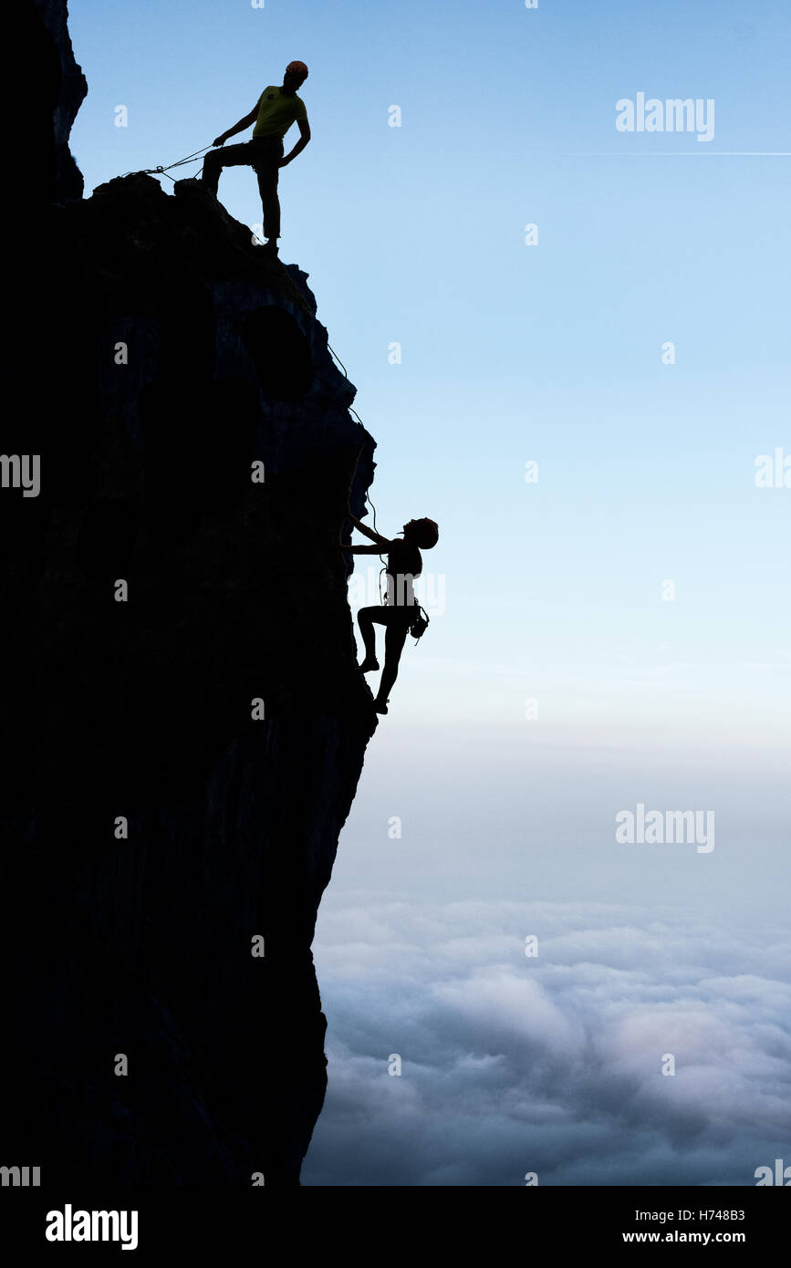 Teamwork couple climbers in the wall. The first makes safety the second ...