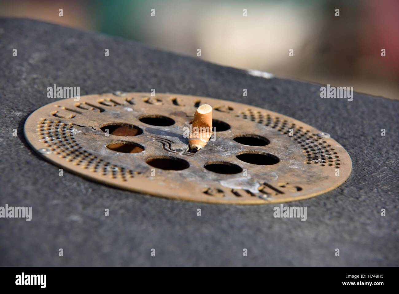 An outdoor street ashtray with a cigarette stub on top UK Stock Photo ...