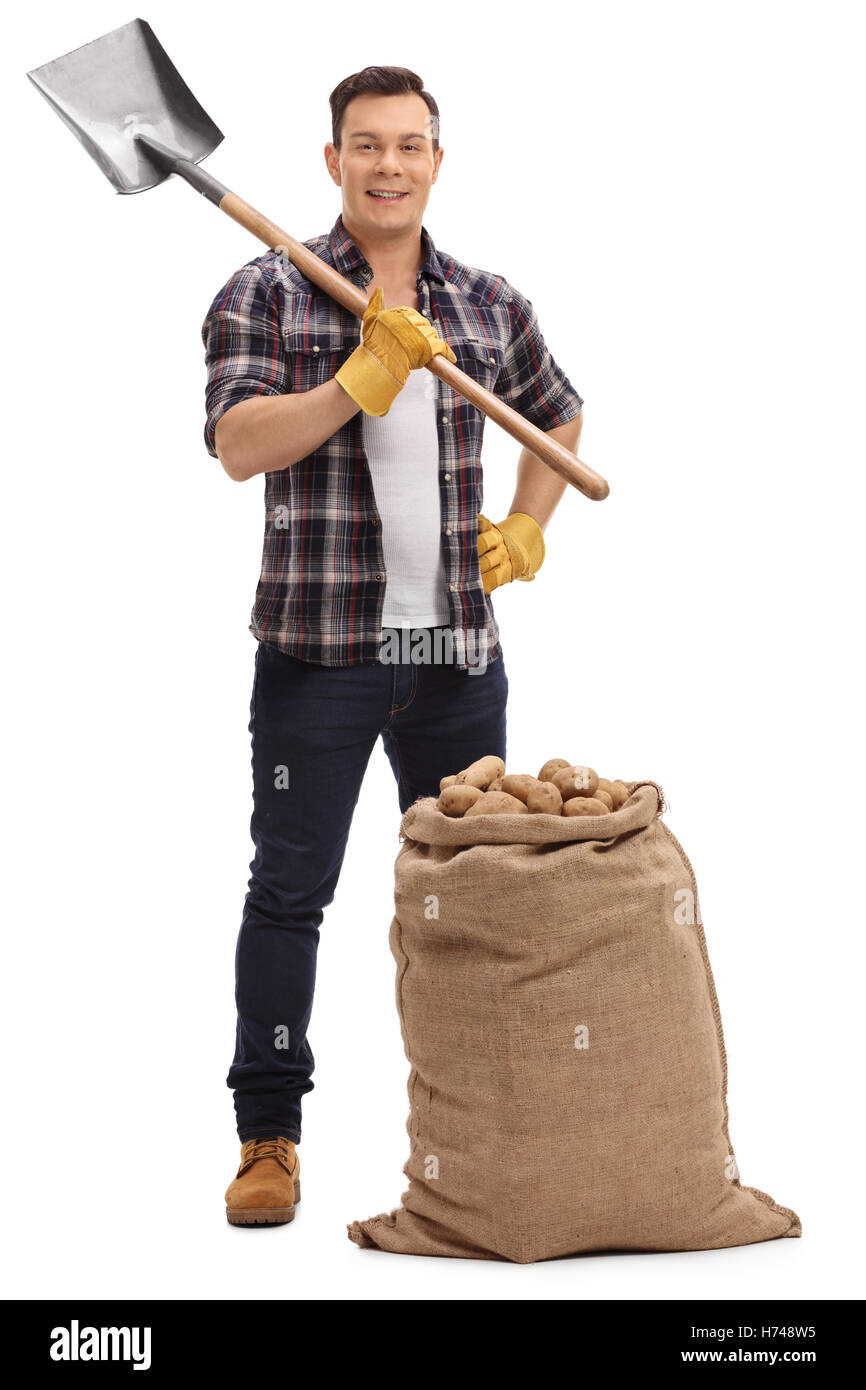 Full length portrait of a male agricultural worker posing with a shovel ...