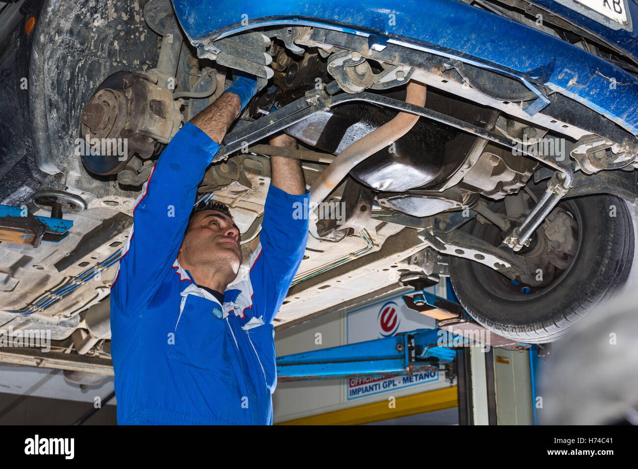 Car mechanic fixing an engine in his garage. copy space Stock Photo - Alamy