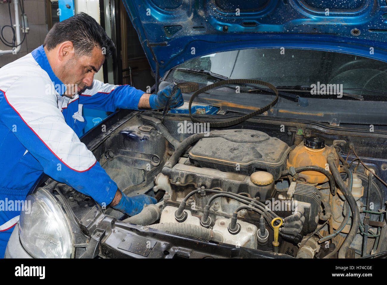 Car mechanic fixing an engine in his garage. copy space Stock Photo - Alamy