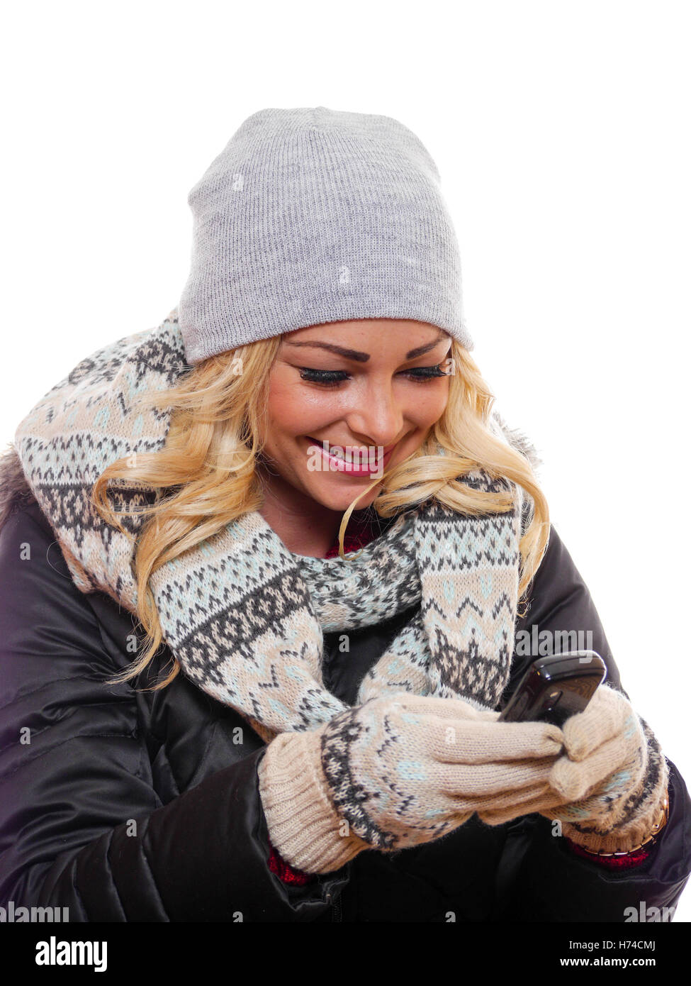 A attractive woman is texting on her cell phone while smiling Stock ...