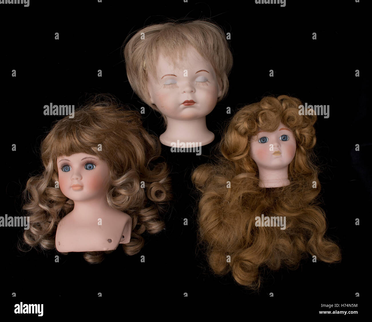 Three Doll Heads on Black Background Stock Photo - Alamy