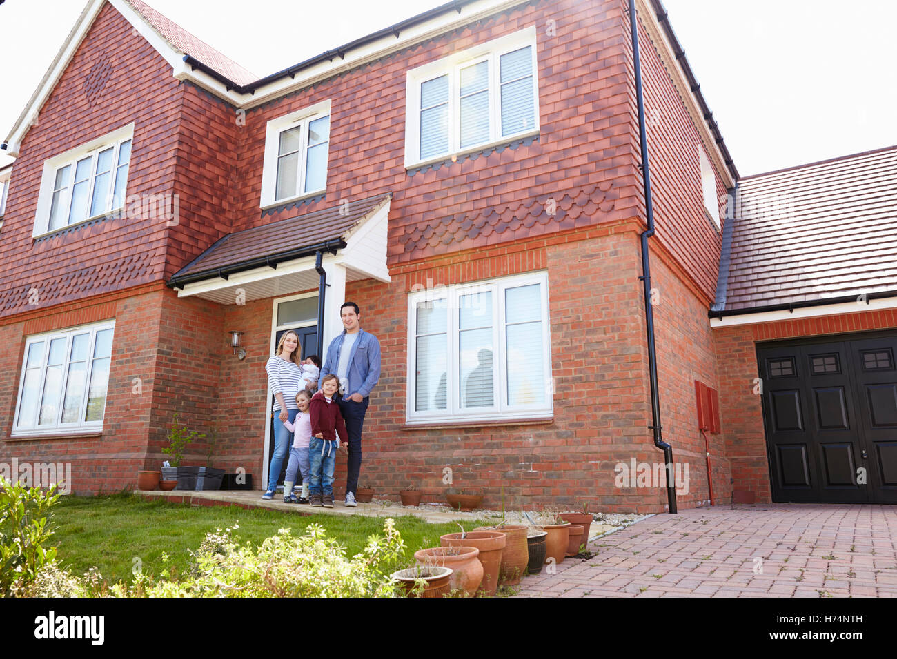 Portrait Of Young Family Standing Outside New Home Stock Photo - Alamy