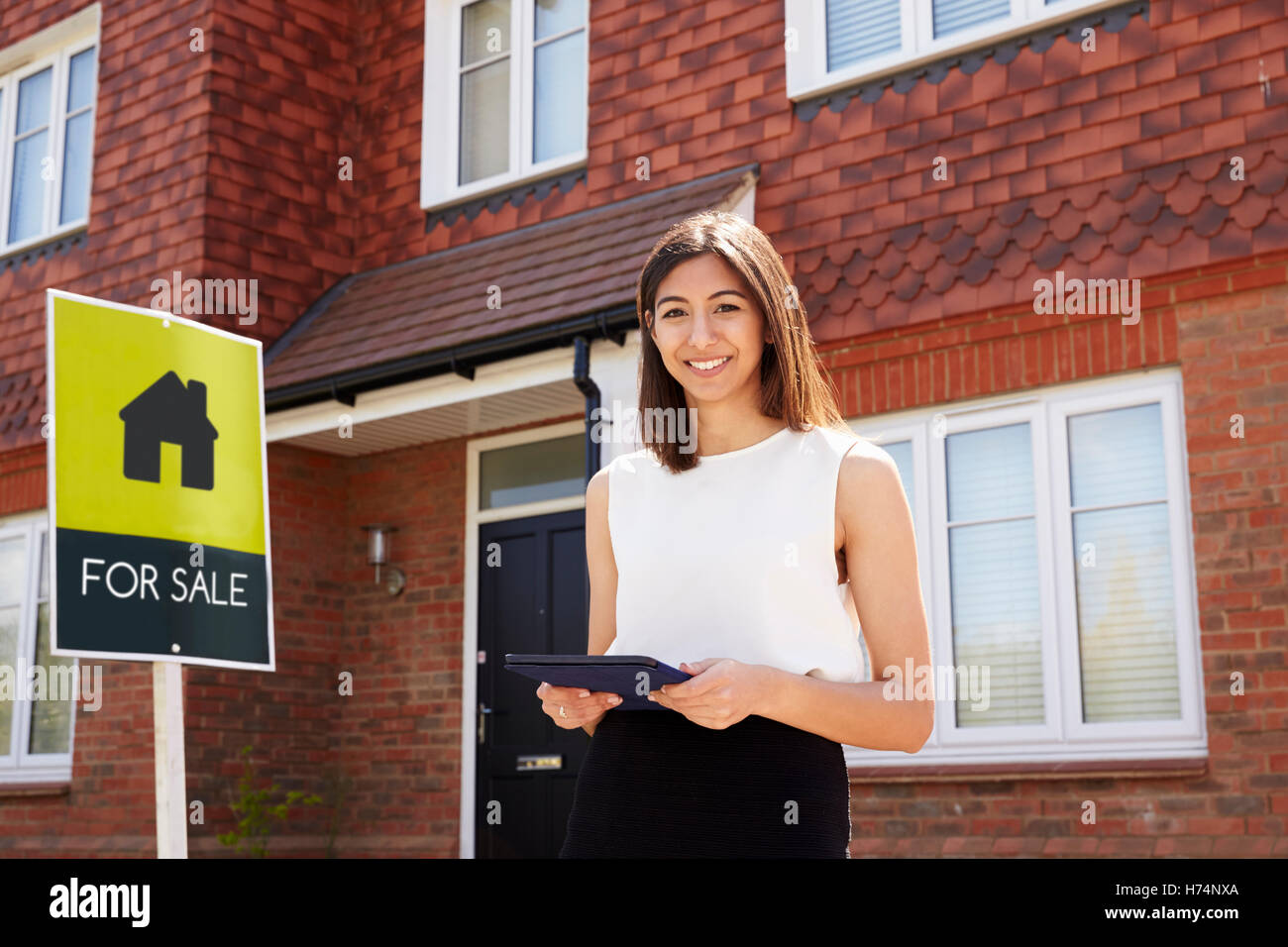 Female Realtor Standing Outside Residential Property Stock Photo - Alamy
