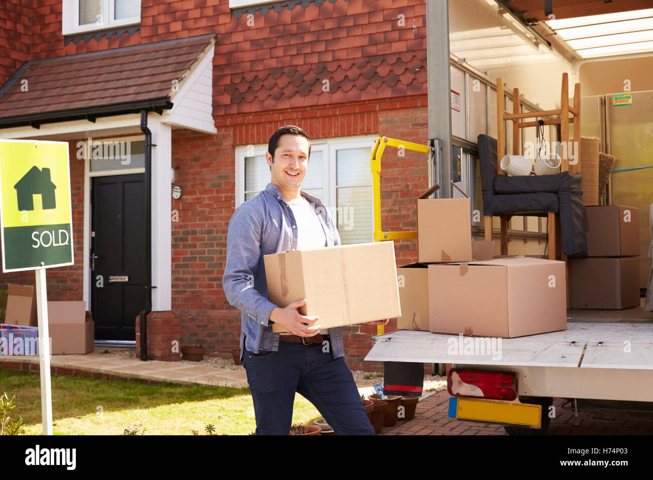 Man Unpacking Moving In Boxes From Removal Truck Stock Photo - Alamy