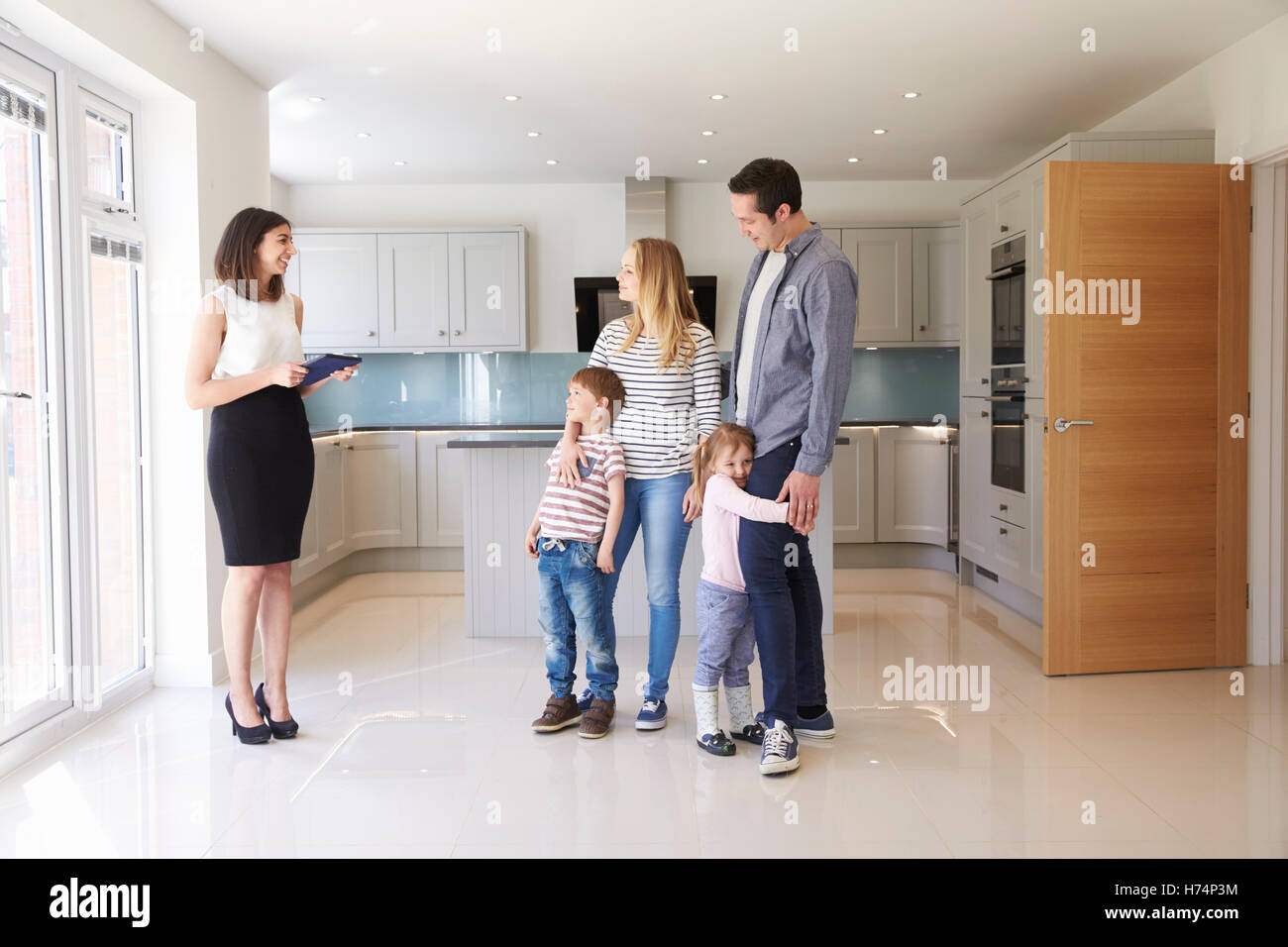 Realtor Showing Young Family Around Property For Sale Stock Photo - Alamy