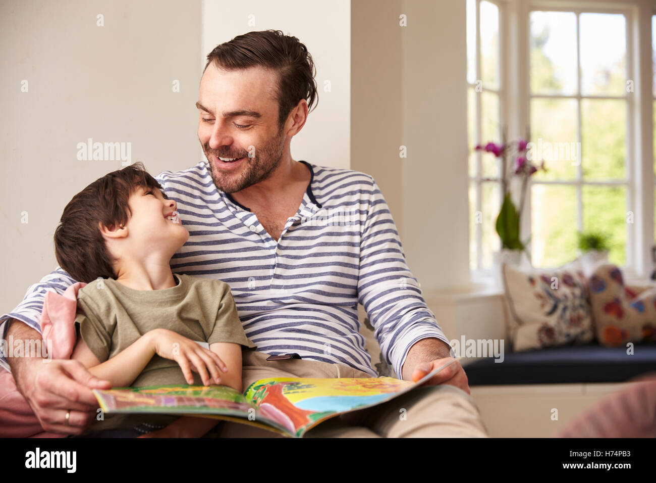 Father And Son Reading Story At Home Together Stock Photo - Alamy
