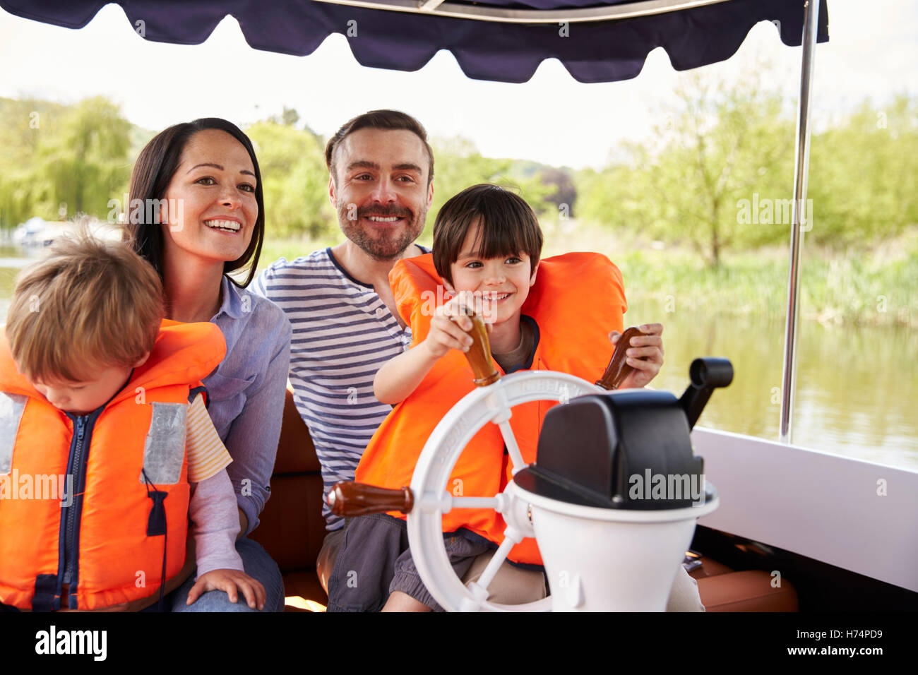 Family Enjoying Day Out In Boat On River Together Stock Photo - Alamy