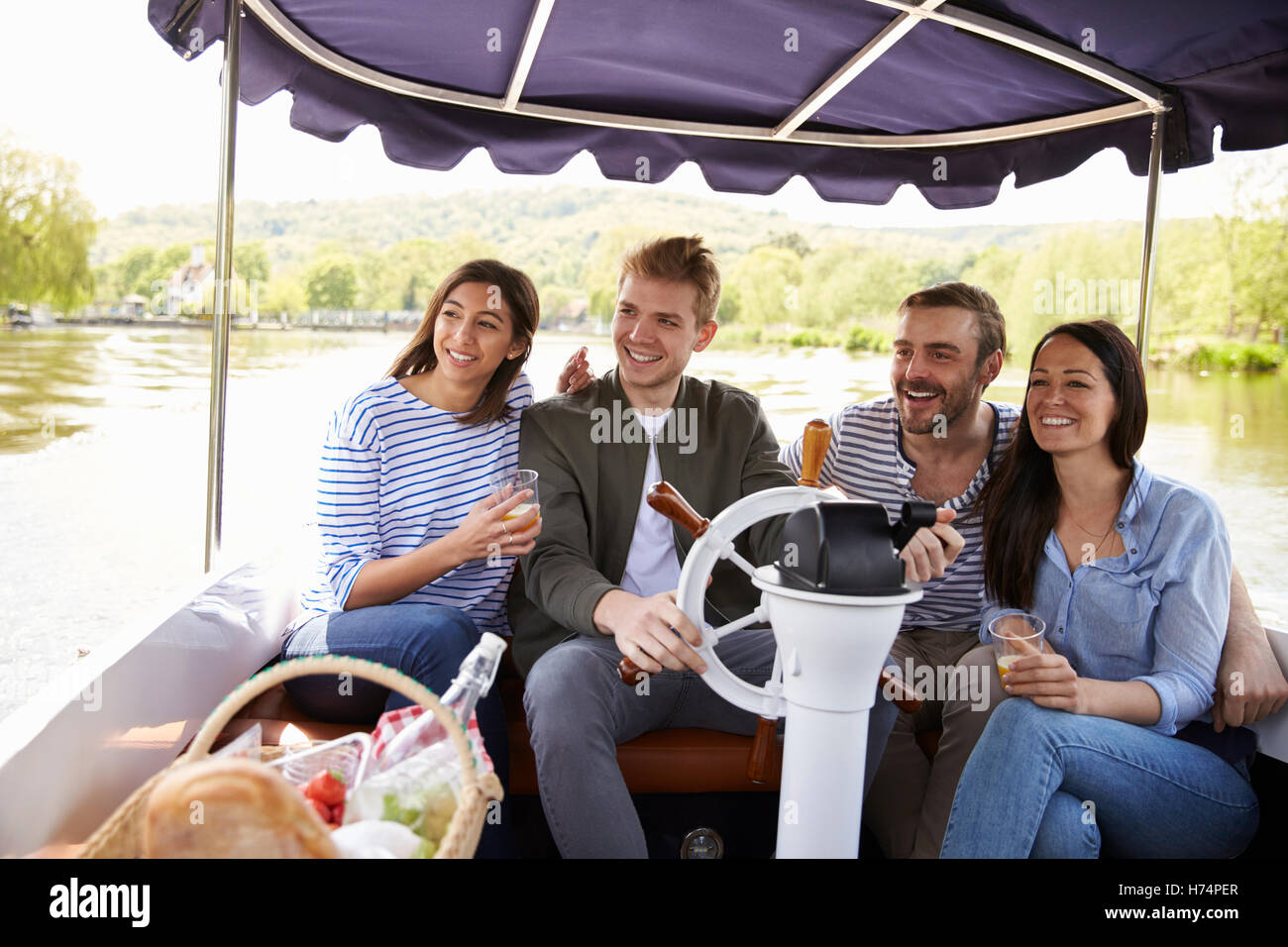 Group Of Friends Enjoying Day Out In Boat On River Together Stock Photo ...