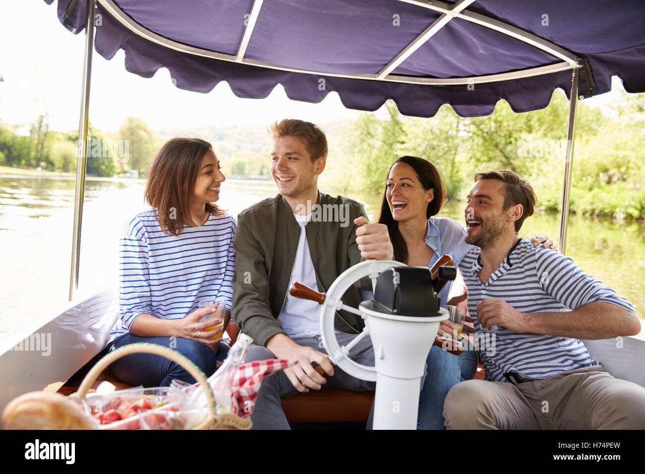 Group Of Friends Enjoying Day Out In Boat On River Together Stock Photo ...