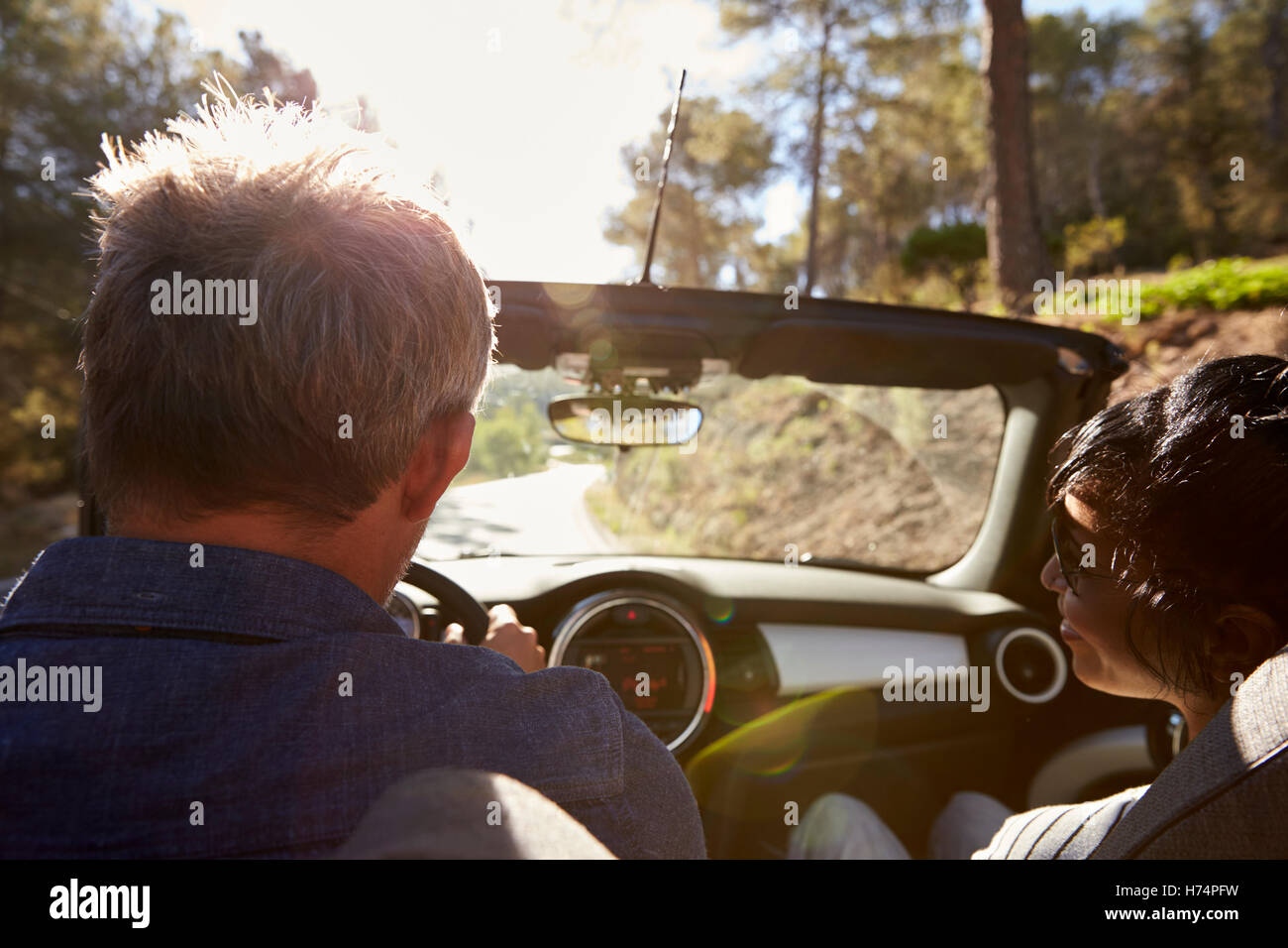 Couple driving in open top car, rear passenger point of view Stock ...