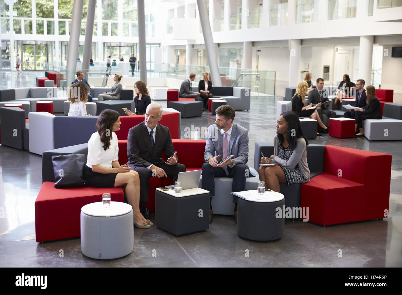 Businesspeople Meeting In Busy Lobby Of Modern Office Stock Photo - Alamy