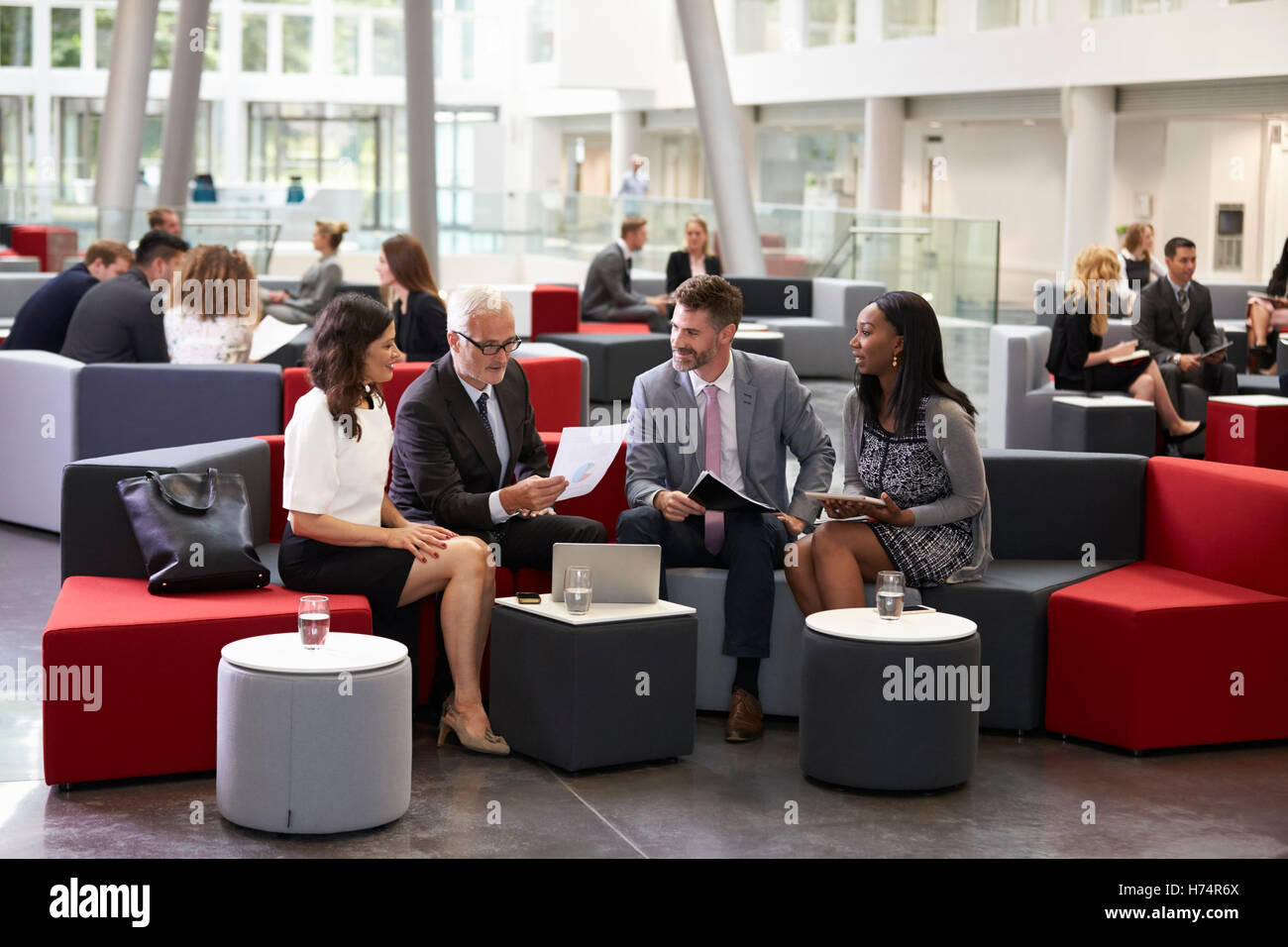 Businesspeople Meeting In Busy Lobby Of Modern Office Stock Photo - Alamy