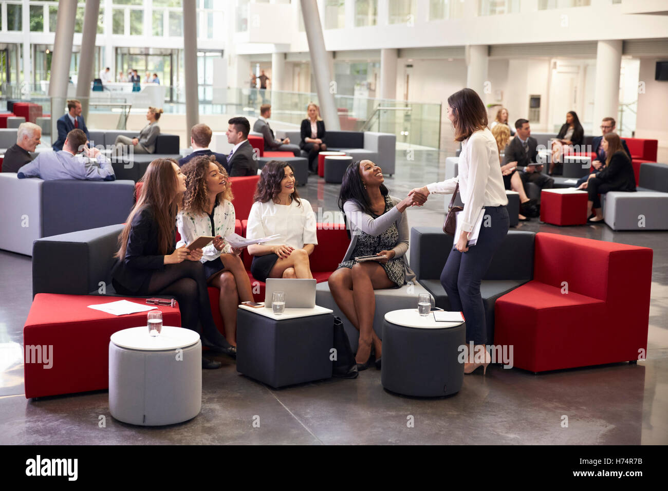 Businesswomen Meeting In Busy Lobby Of Modern Office Stock Photo - Alamy
