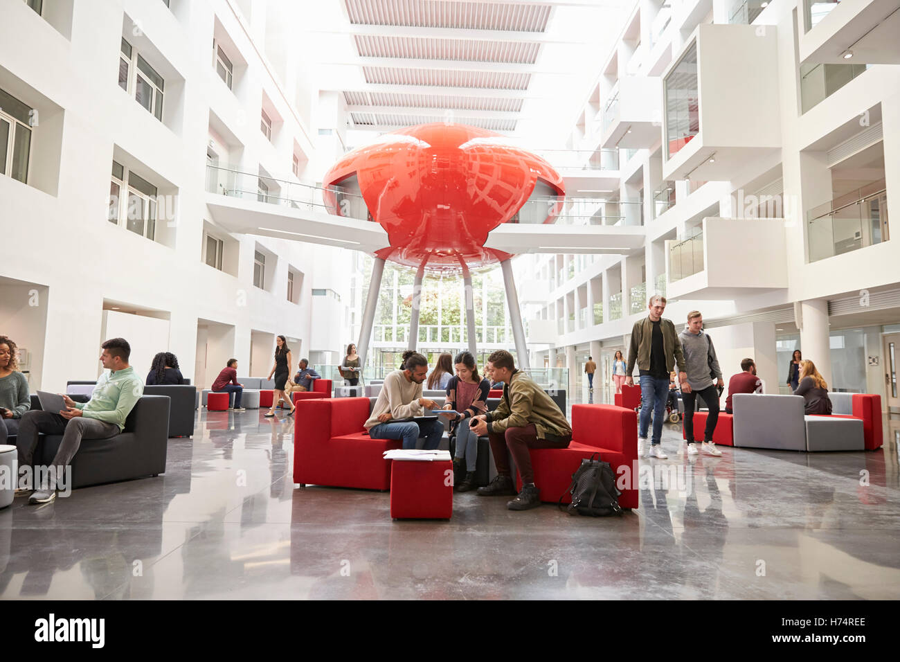 Students socialising in the lobby of modern university Stock Photo - Alamy