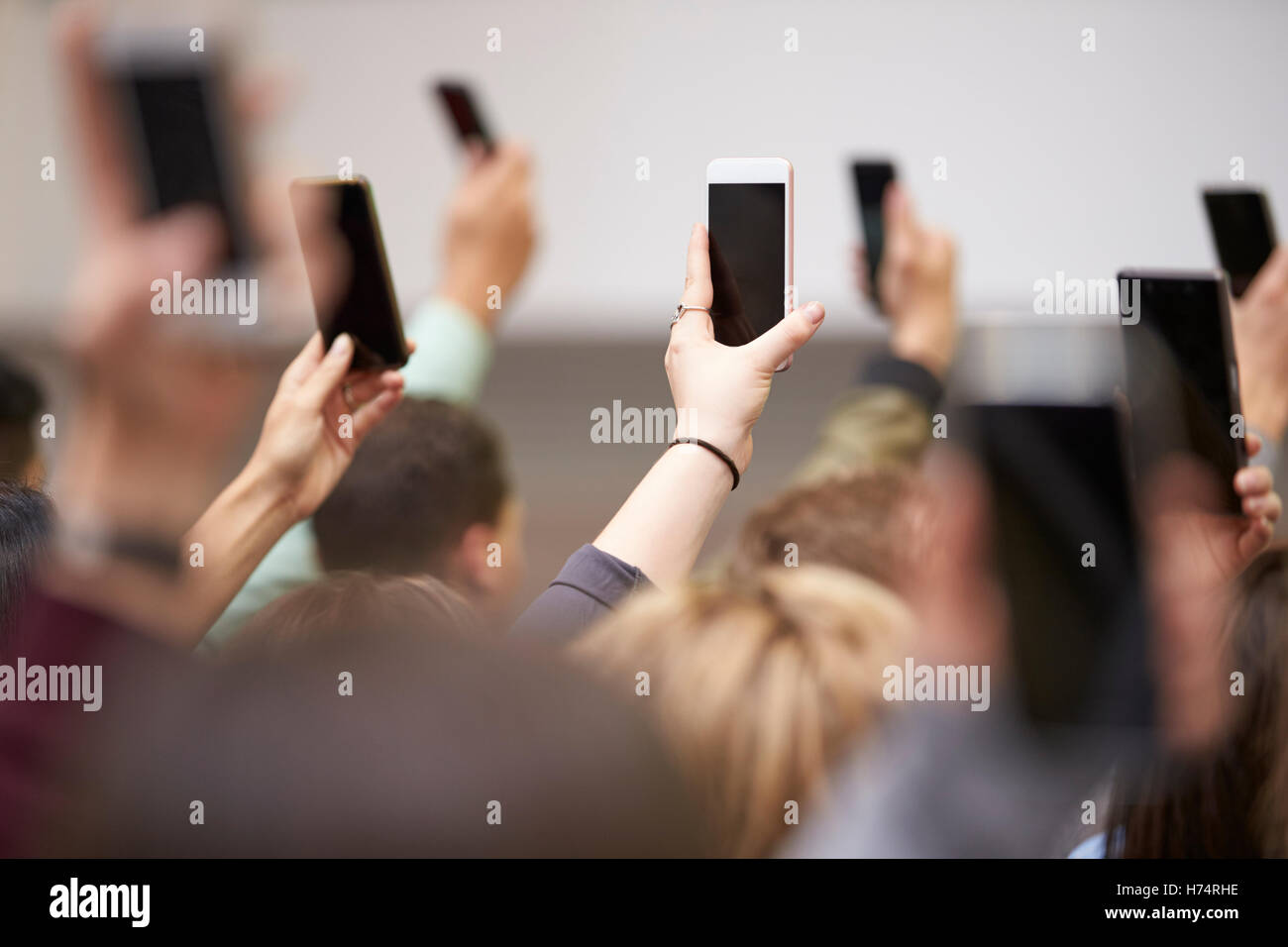 Hands in a crowd holding phones up to take pictures Stock Photo - Alamy
