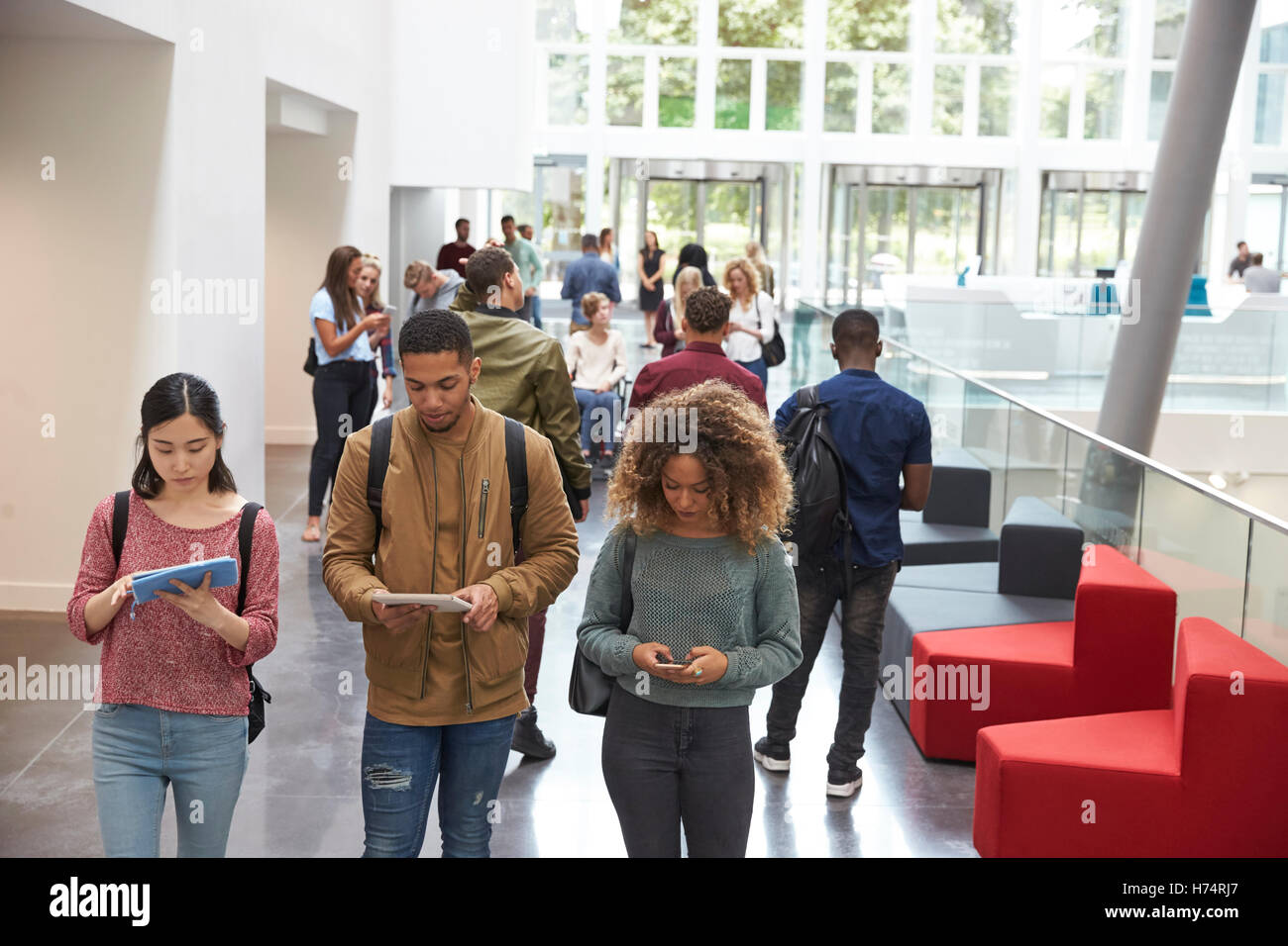 Students walk in university campus using tablets and phone Stock Photo ...
