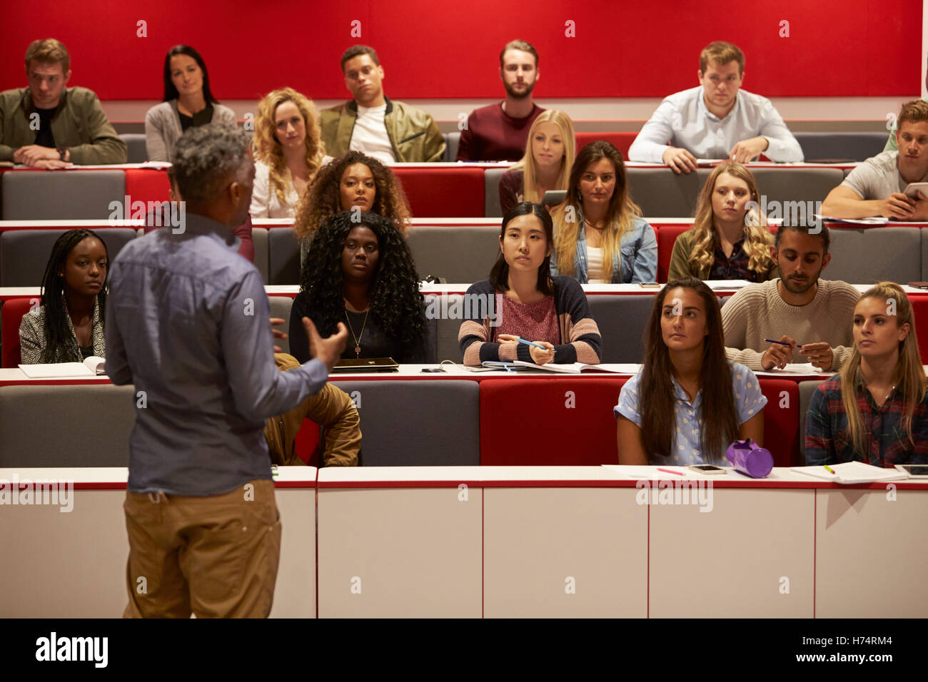 Back view of man presenting to students at a lecture theatre Stock ...