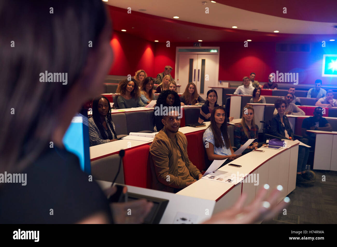 Woman lecturing students in lecture theatre, focus midground Stock ...