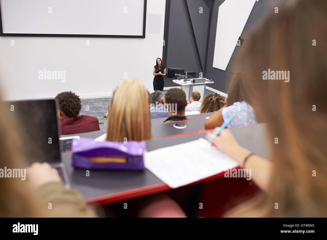 Woman lecturing students in a lecture theatre, student POV Stock Photo ...
