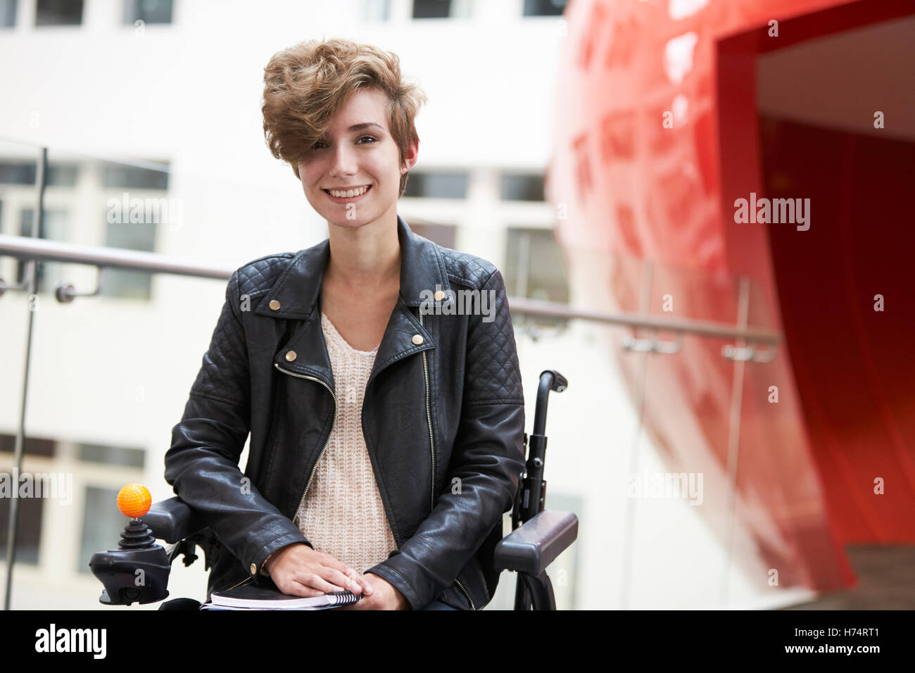 Smiling disabled female university student on mezzanine Stock Photo - Alamy