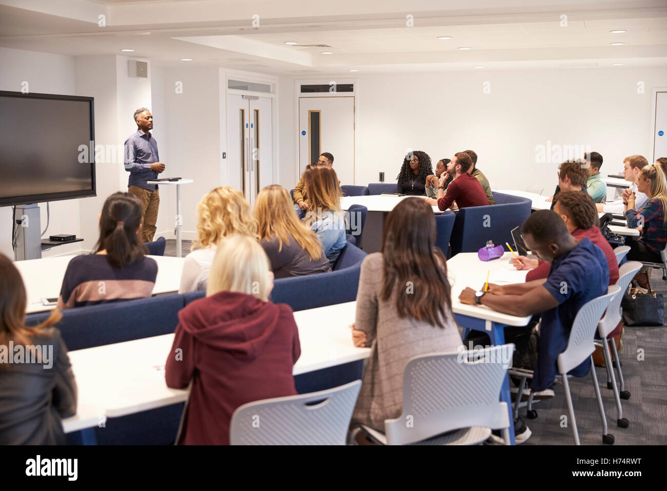 University students study in a classroom with male lecturer Stock Photo ...