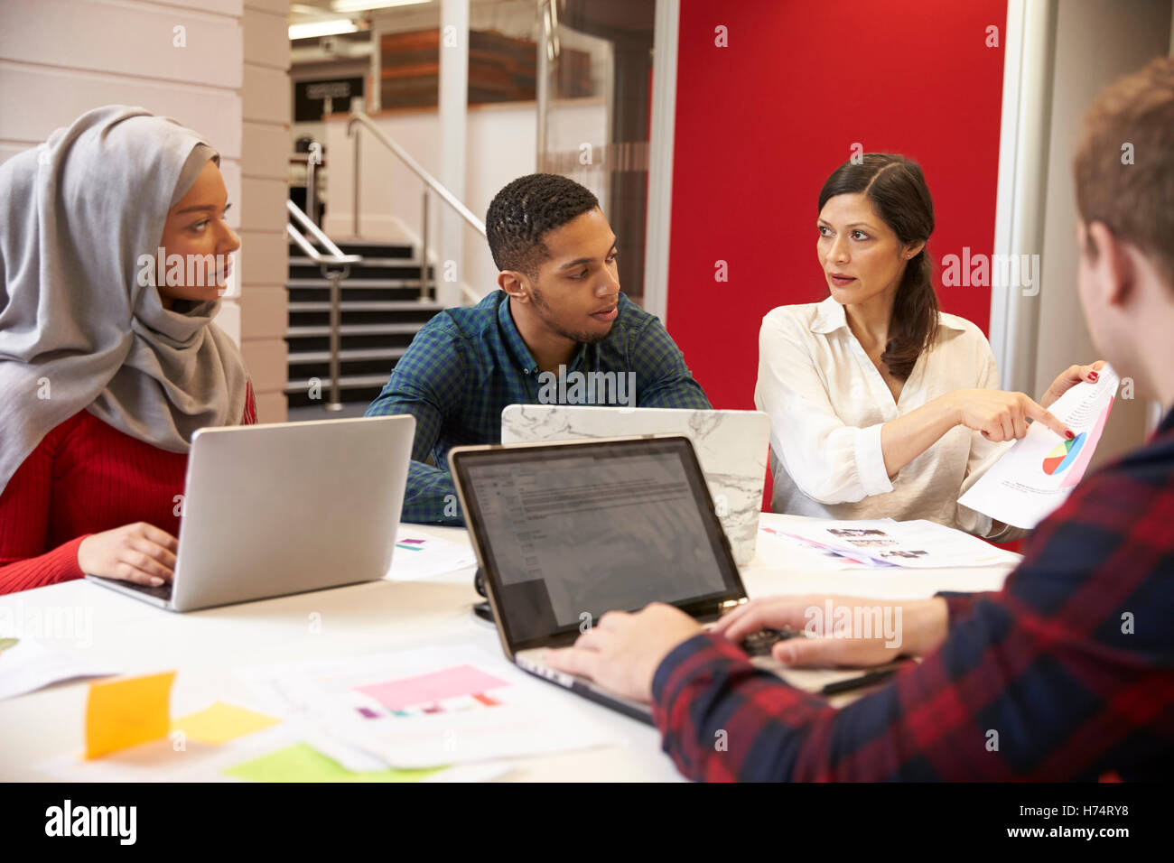 Group Of Students Meeting For Tutorial With Teacher Stock Photo - Alamy