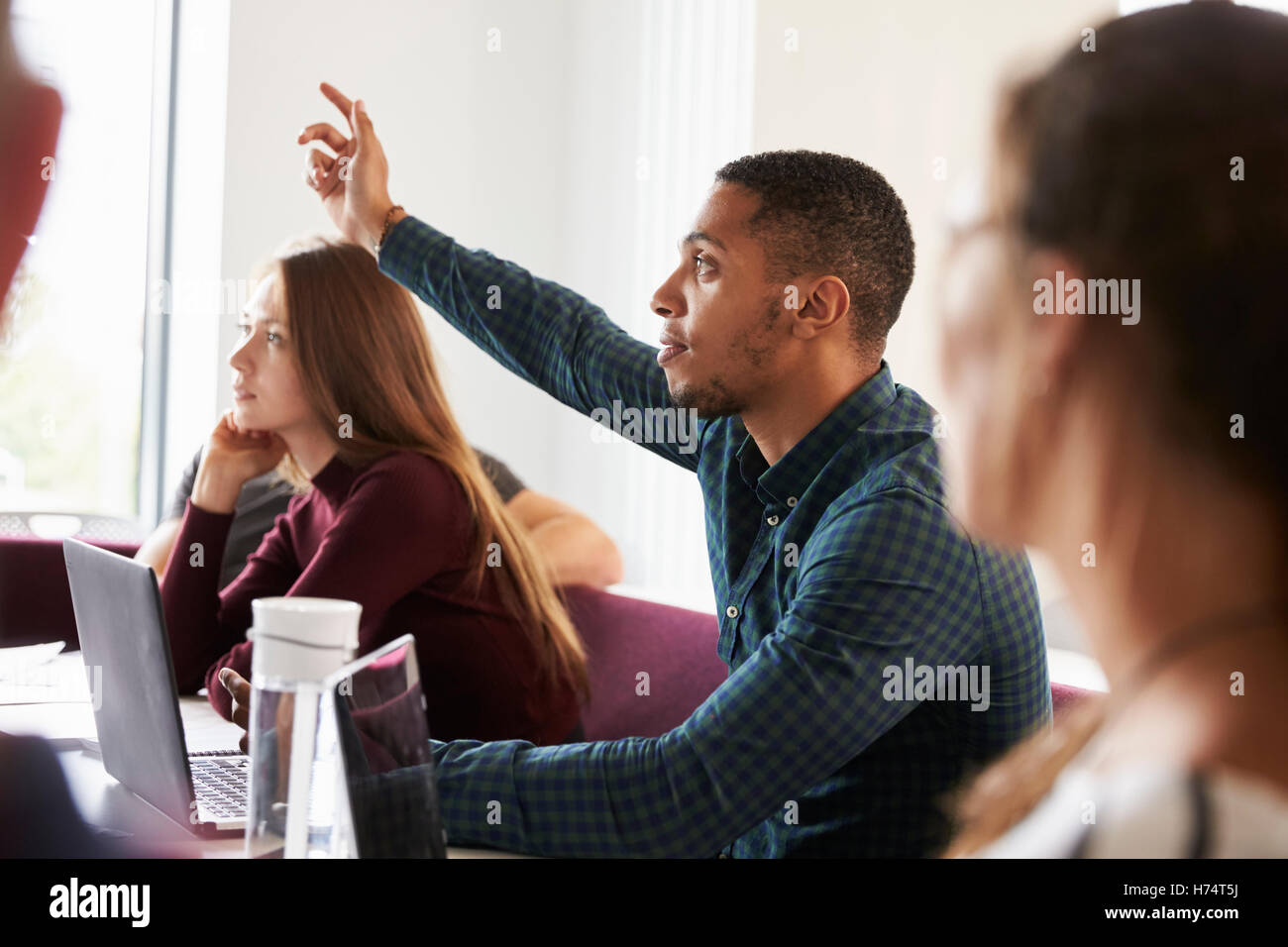 Students Asking Question Whilst Attending Lecture On Campus Stock Photo ...