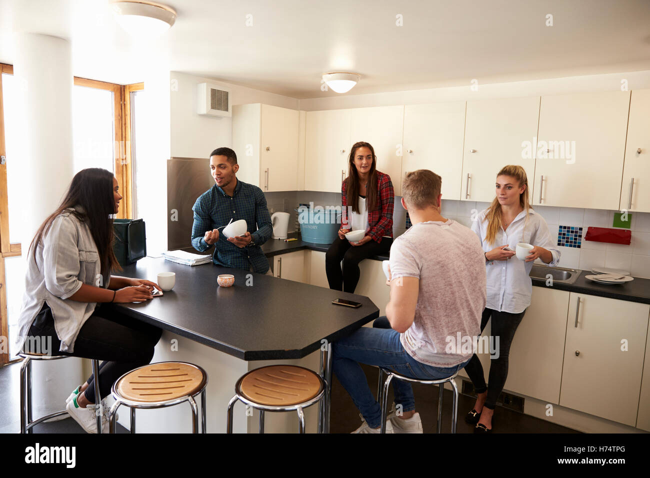 Students Relaxing In Kitchen Of Shared Accommodation Stock Photo - Alamy
