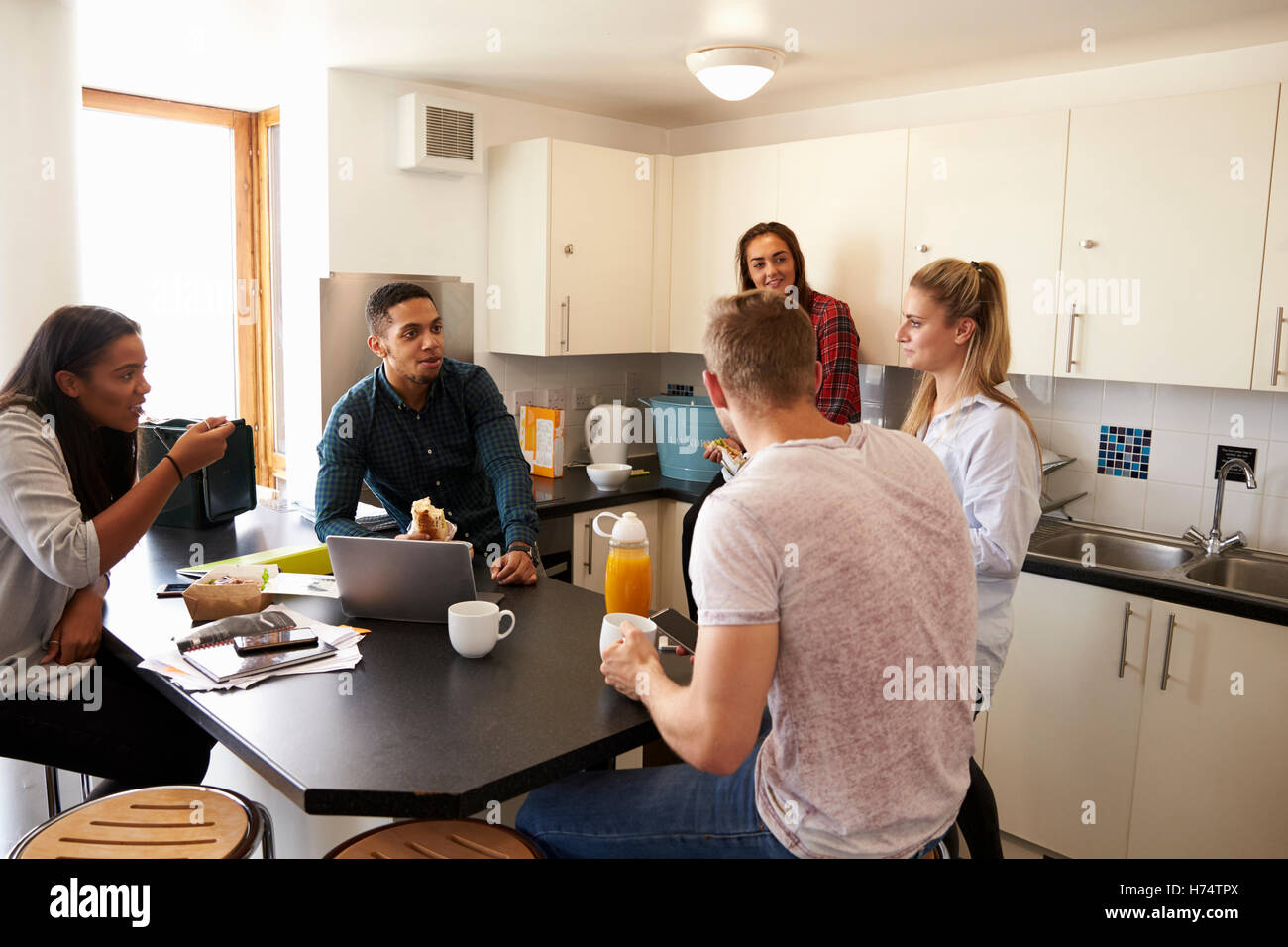 Students Relaxing In Kitchen Of Shared Accommodation Stock Photo - Alamy