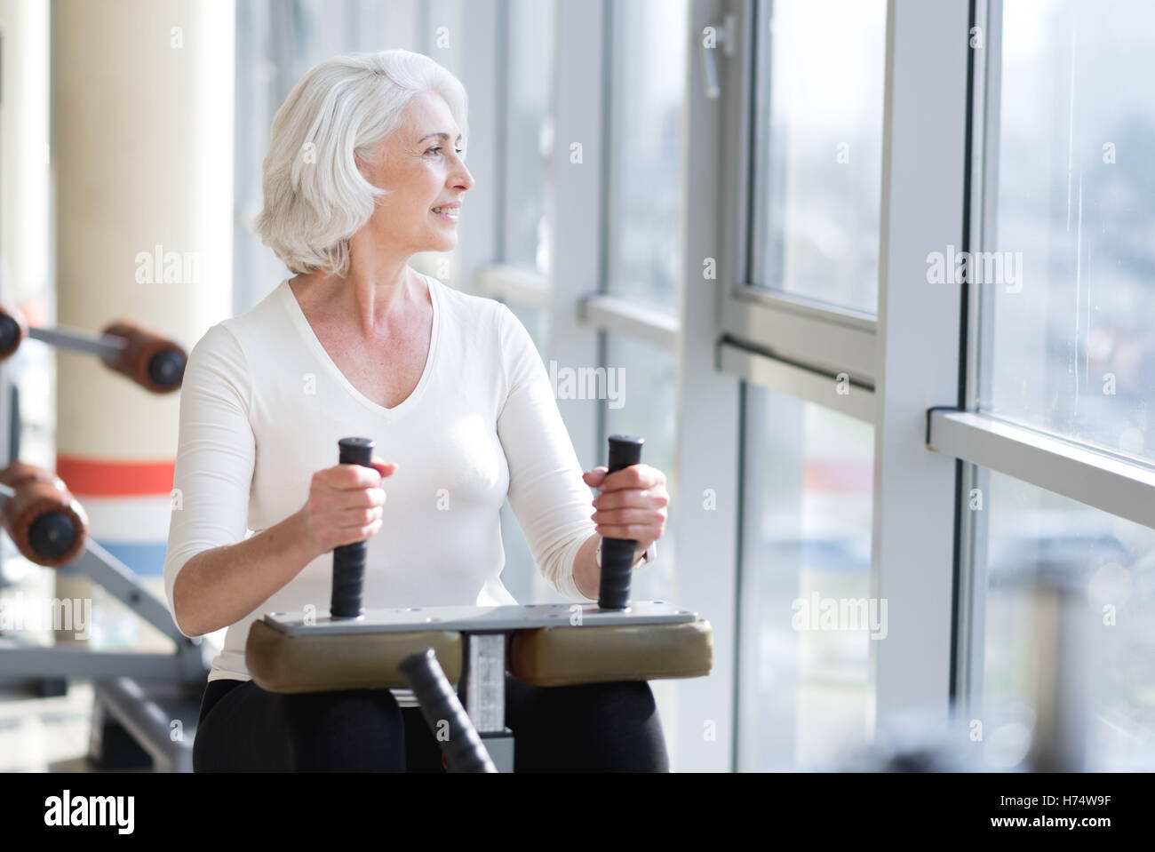 Charming slim senior woman using gym equipment Stock Photo - Alamy