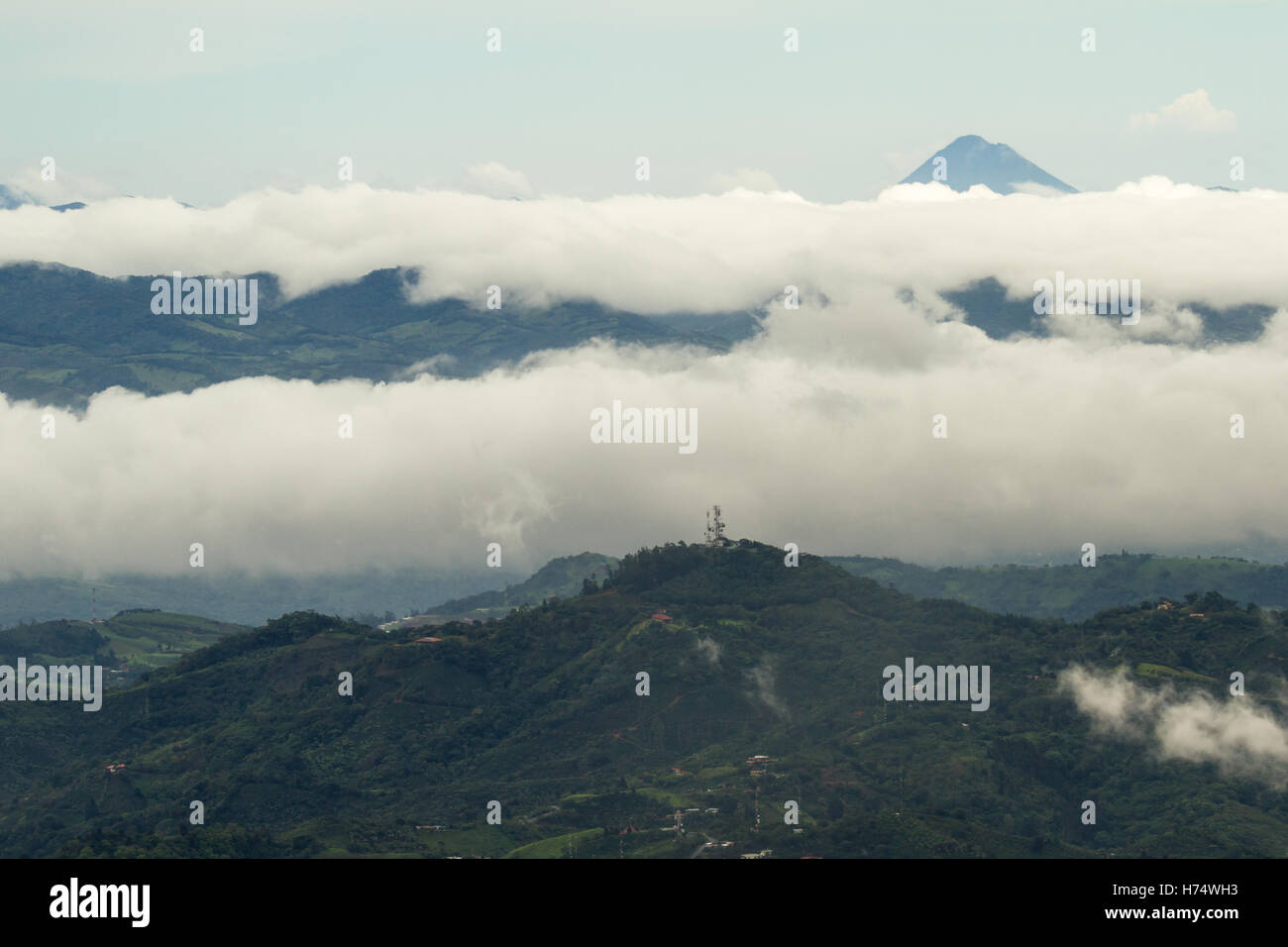 aerial view of the Arenal Volcano in Costa Rica peaking thru the clouds ...