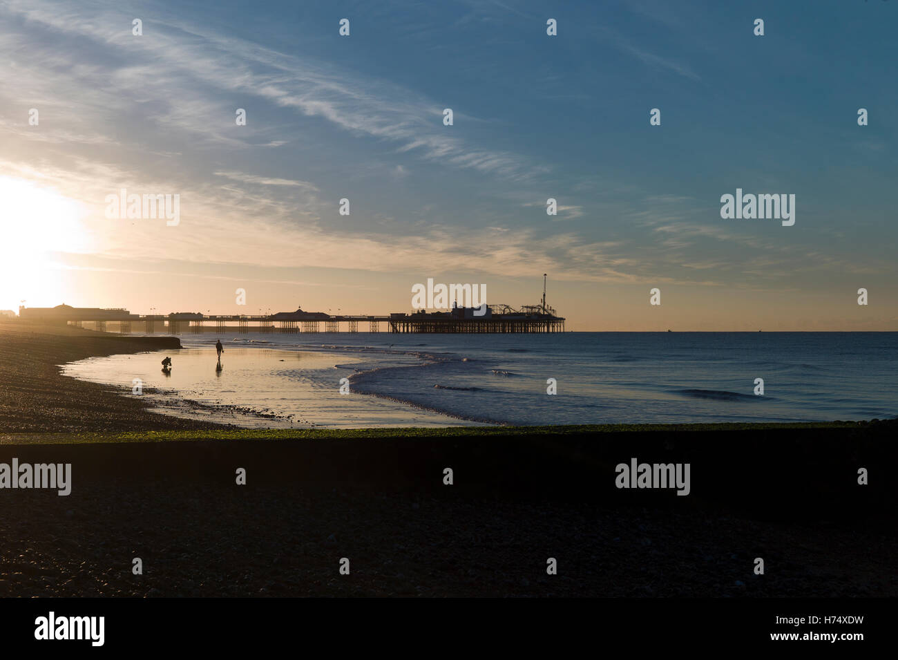 Two distant figures on beach at sunrise, Brighton Stock Photo - Alamy