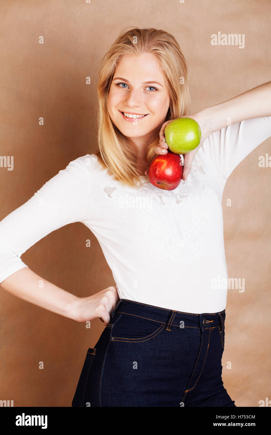 young pretty blond woman choosing between red and green apple sm Stock ...