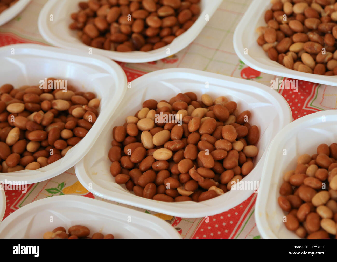 many plastic plates filled with boiled beans during the village feast ...