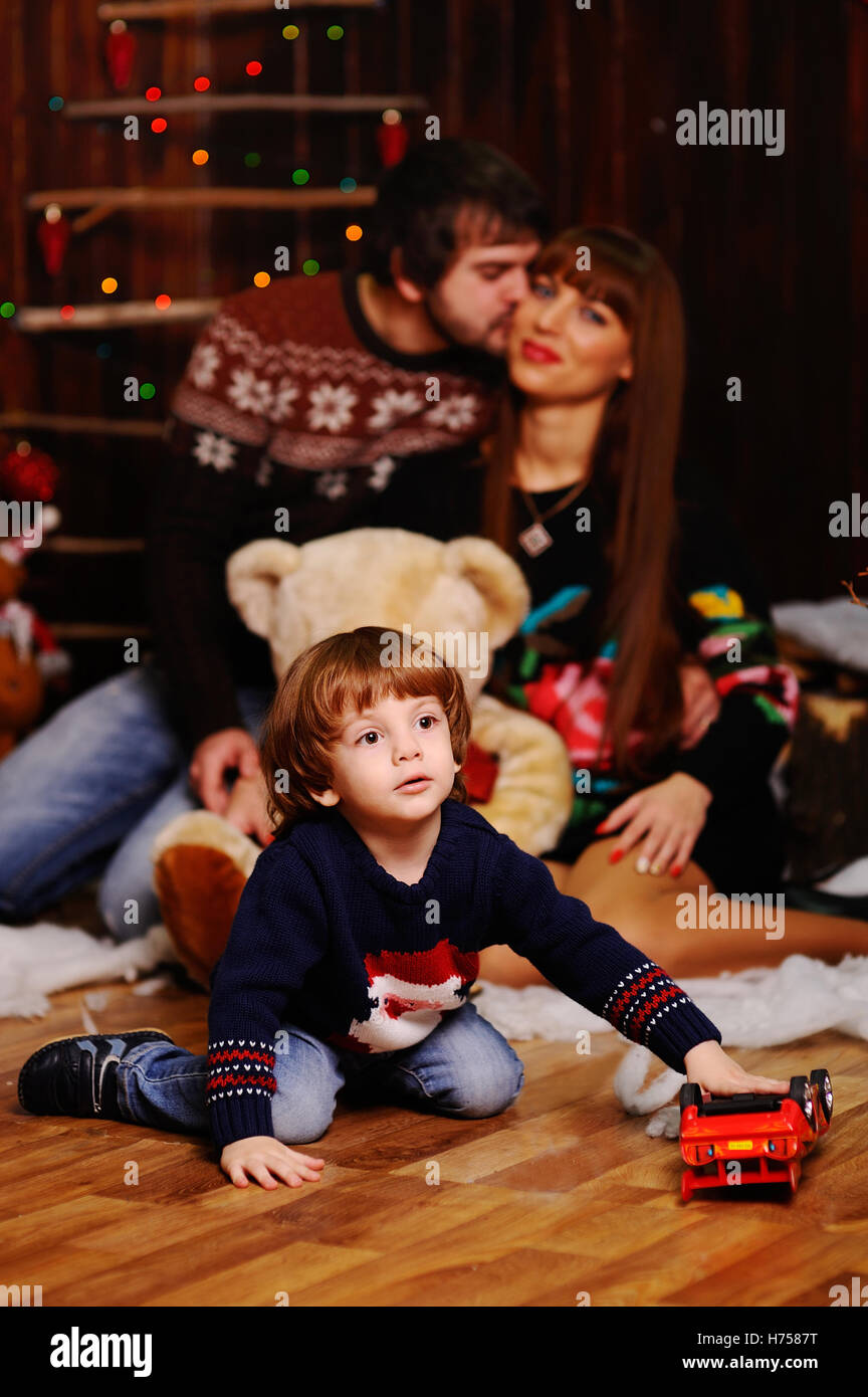 young family sitting under the Christmas tree Stock Photo - Alamy
