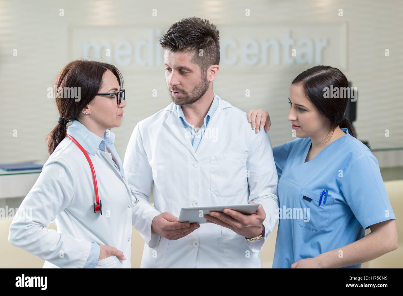 Three doctors using a tablet in bright office Stock Photo - Alamy