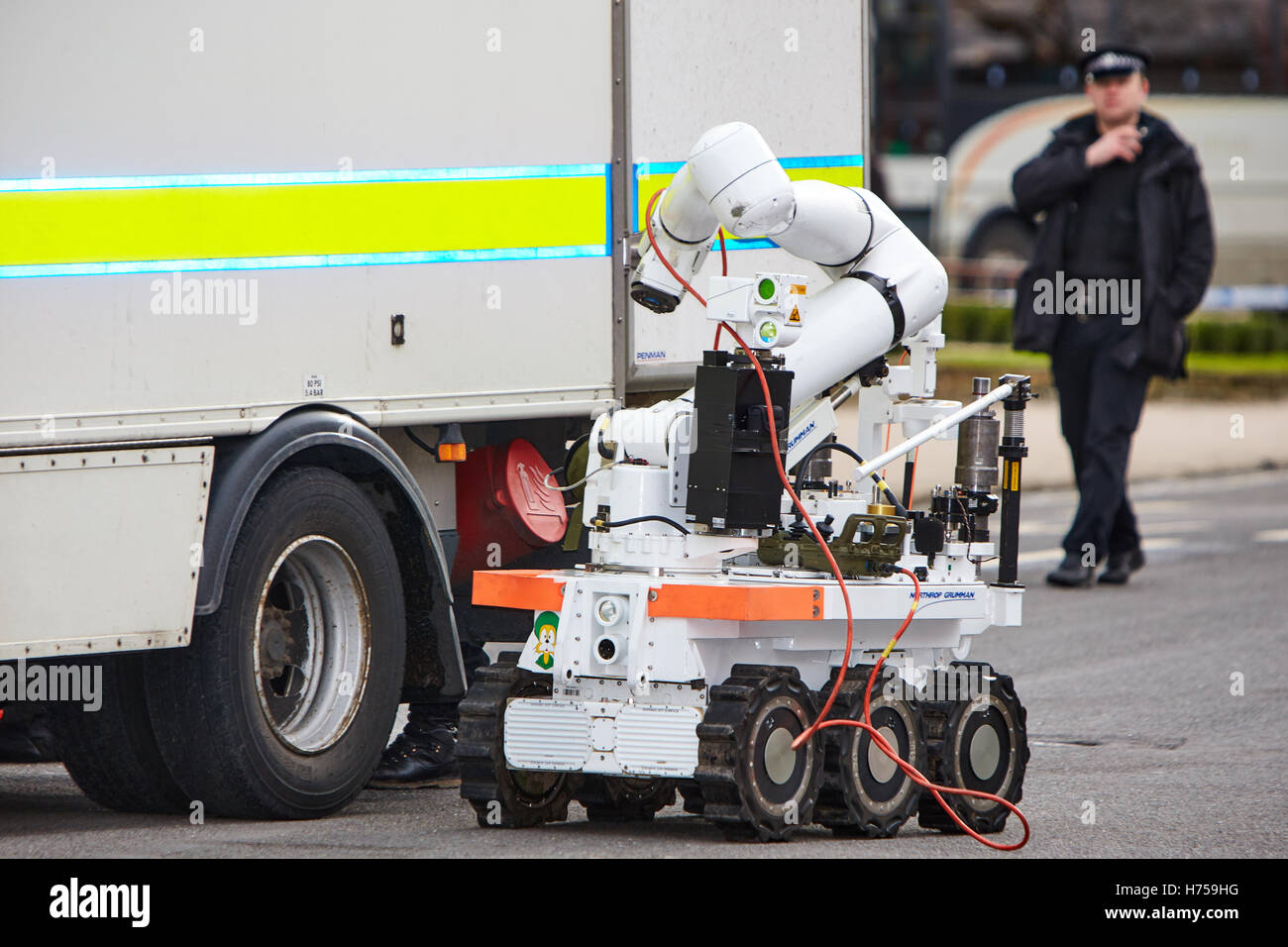Bomb disposal officers prepare a remote robot to deal with a bomb at an ...
