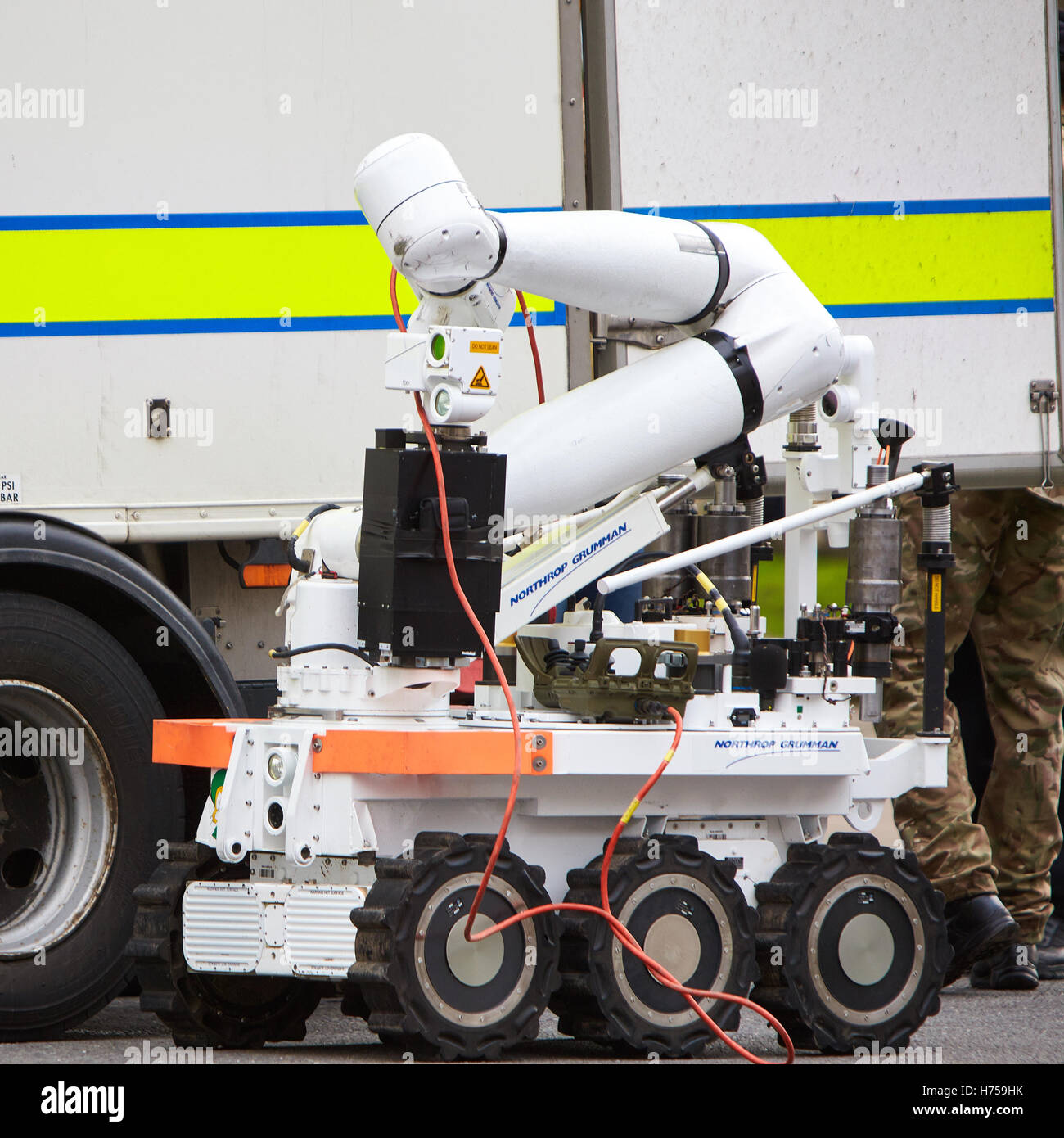 Bomb disposal officers prepare a remote robot to deal with a bomb at an ...