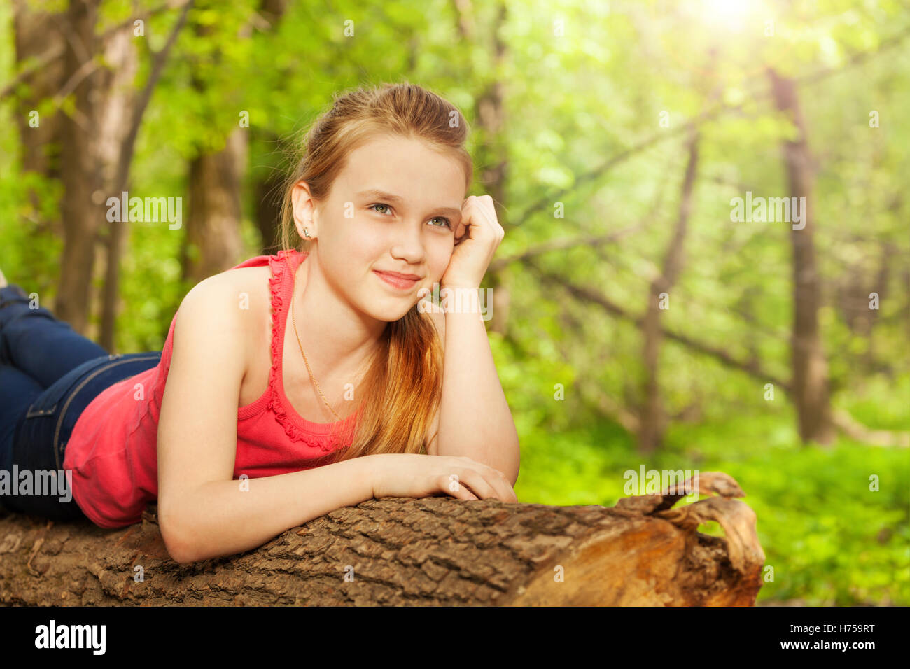 Beautiful thoughtful girl laying on the log Stock Photo - Alamy