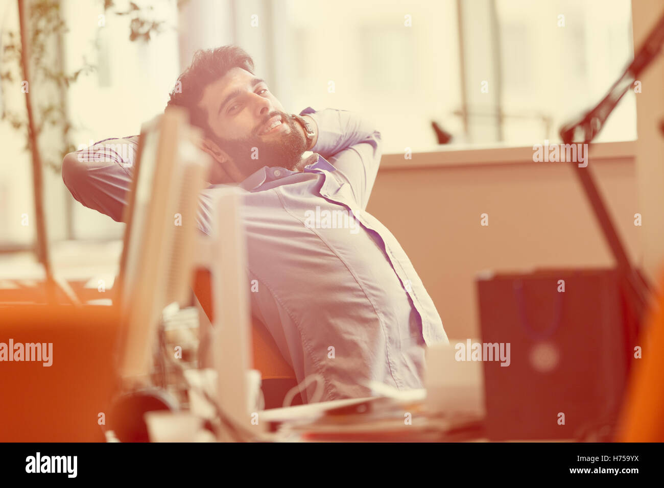 Relaxed businessman at workplace at early morning, relaxing, at startup ...