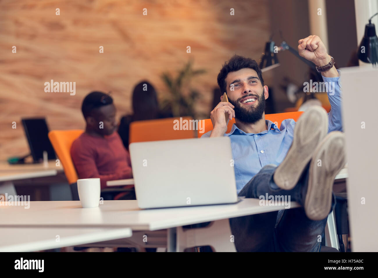 Relaxed businessman at workplace at early morning, relaxing, at startup ...