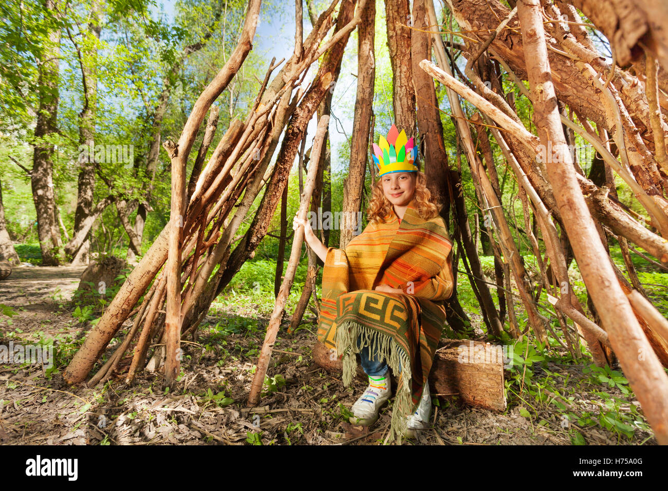 Happy girl playing Red Indian sitting in wigwam Stock Photo - Alamy