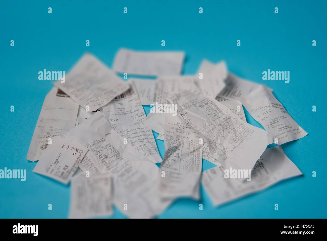 Pile of shopping receipts on a blue background Stock Photo - Alamy