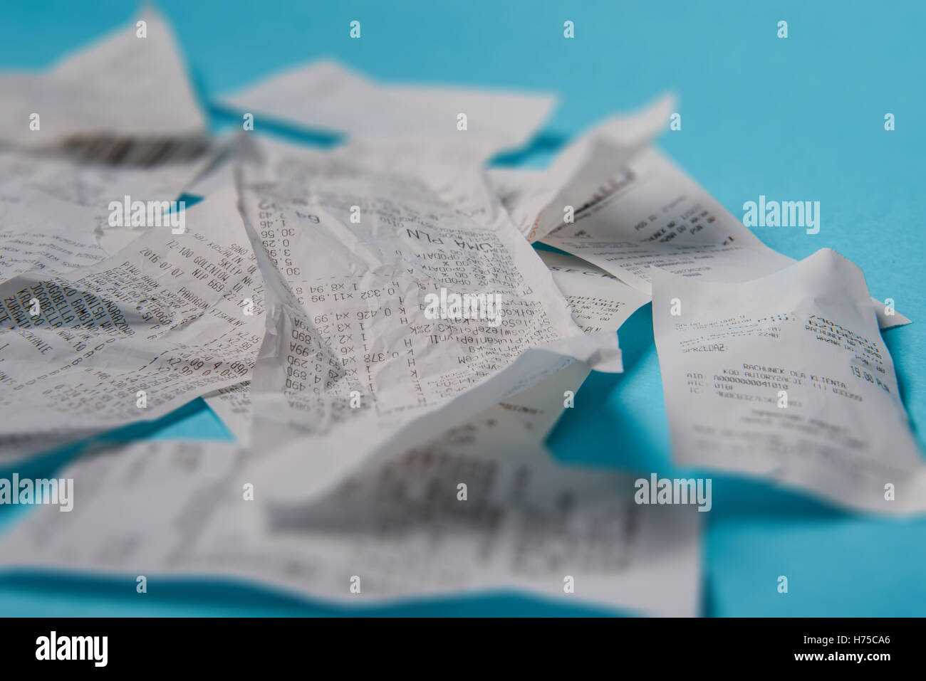 Pile of shopping receipts on a blue background Stock Photo - Alamy